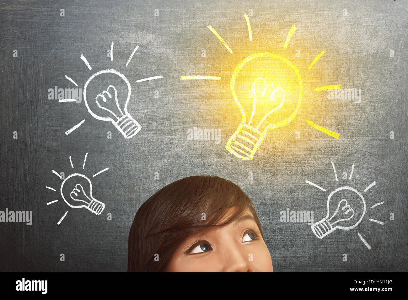 Young asian woman have idea with bright light bulb over head on black ...