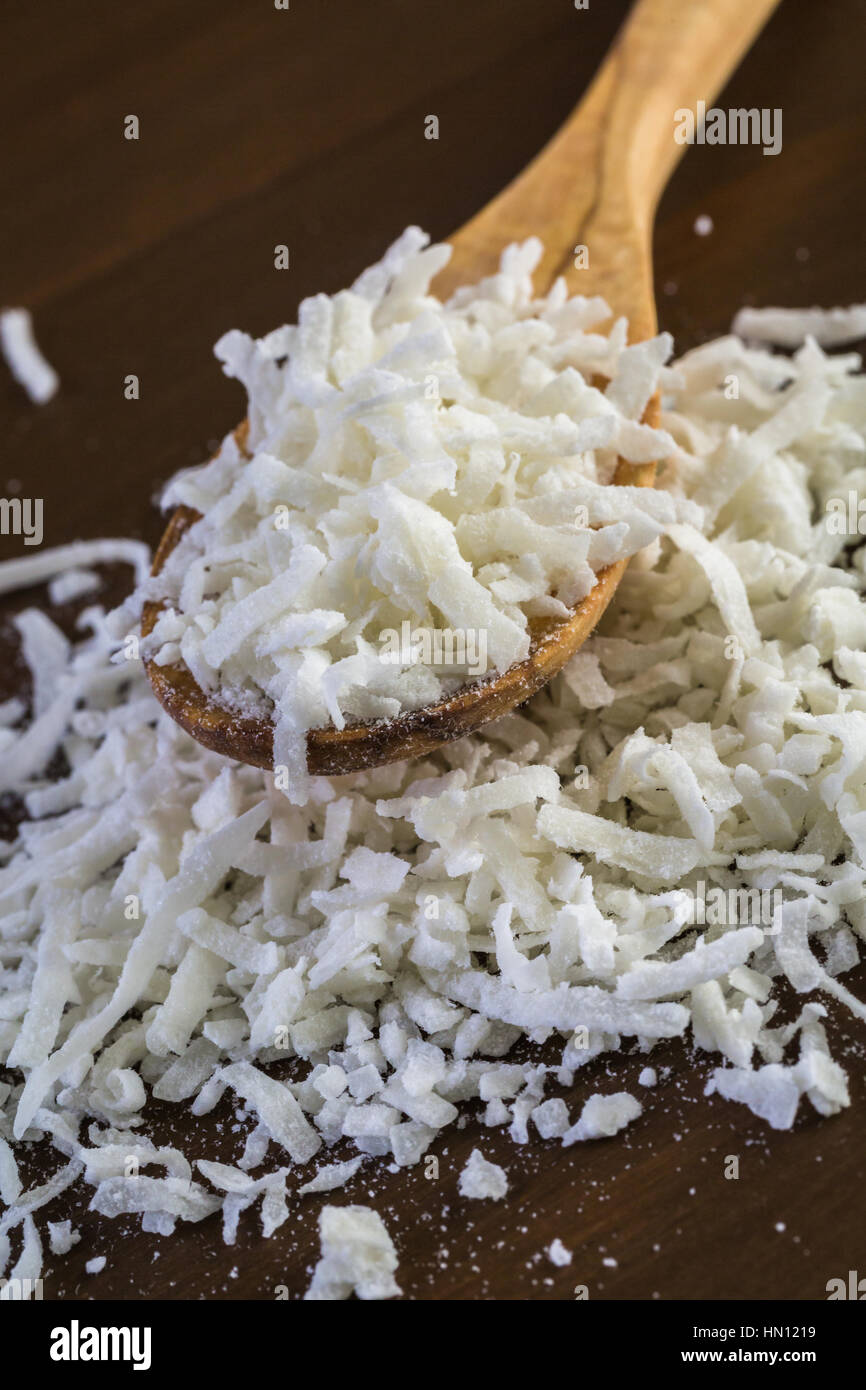 Dehydrated coconut flakes on a wood background Stock Photo - Alamy