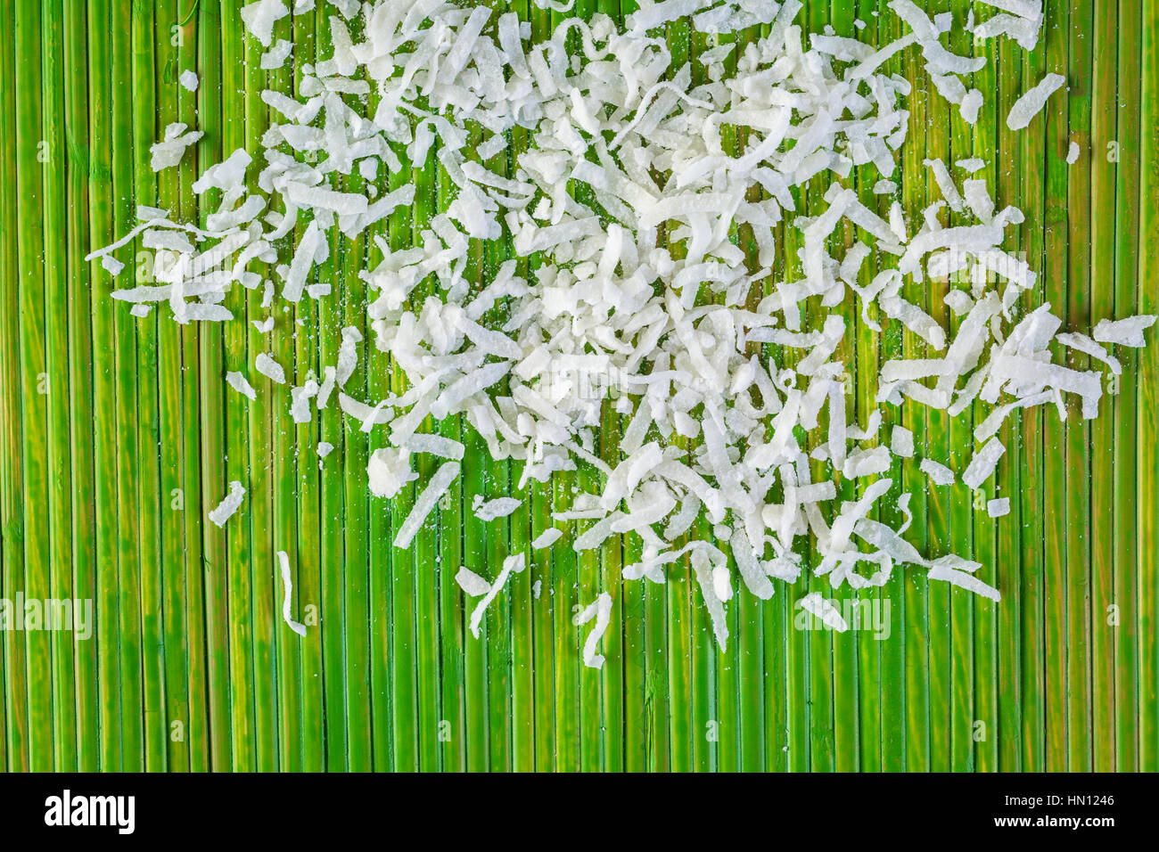 Dehydrated coconut flakes on a green background Stock Photo - Alamy