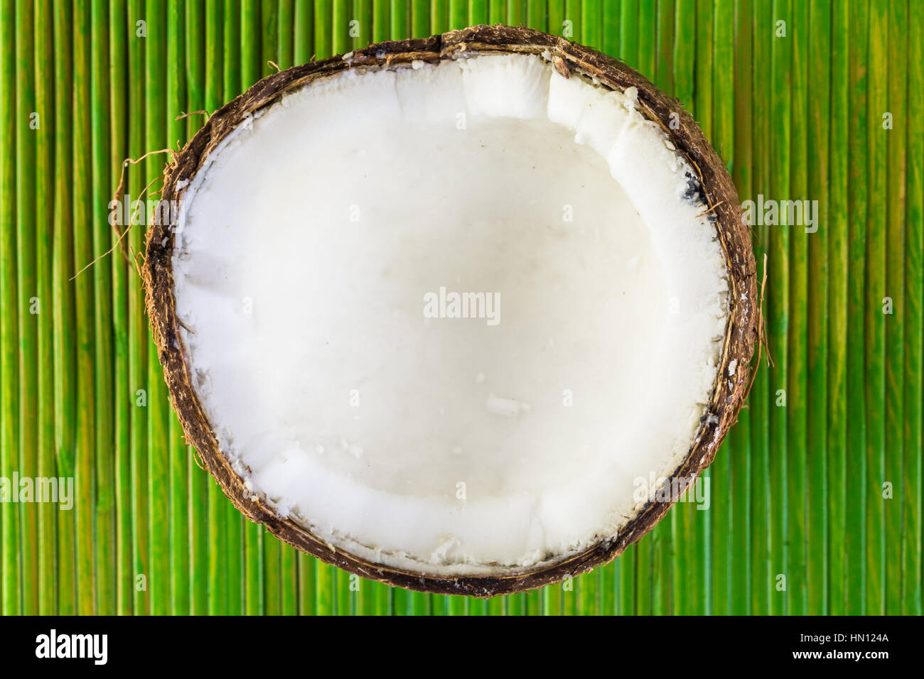 fresh opened coconut on a green background Stock Photo - Alamy