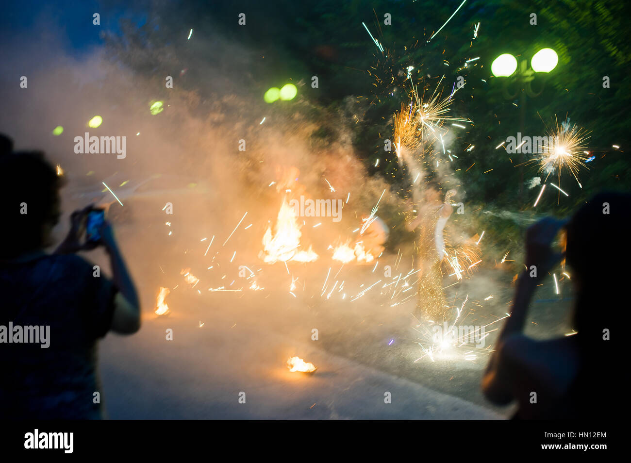 fire show in the open air in the dark. man and woman show tricks with ...