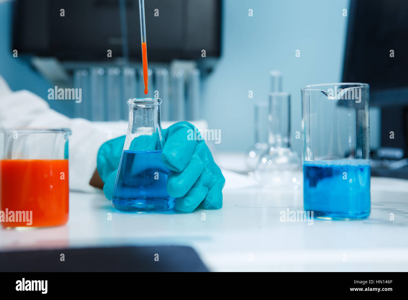 Laboratorian with flask on table in chemistry lab Stock Photo - Alamy