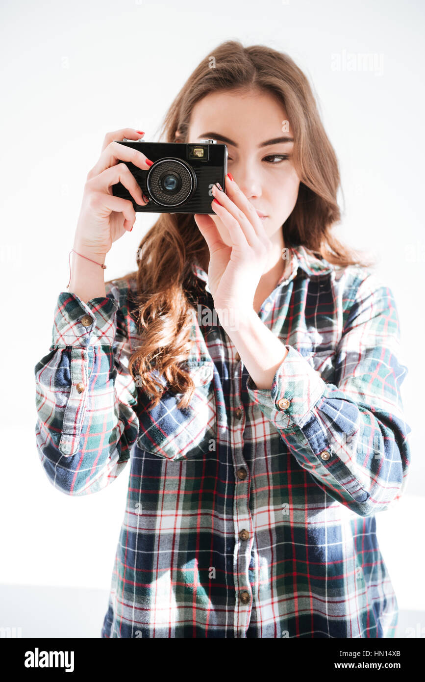 Image of young lady holding camera while standing over white background ...