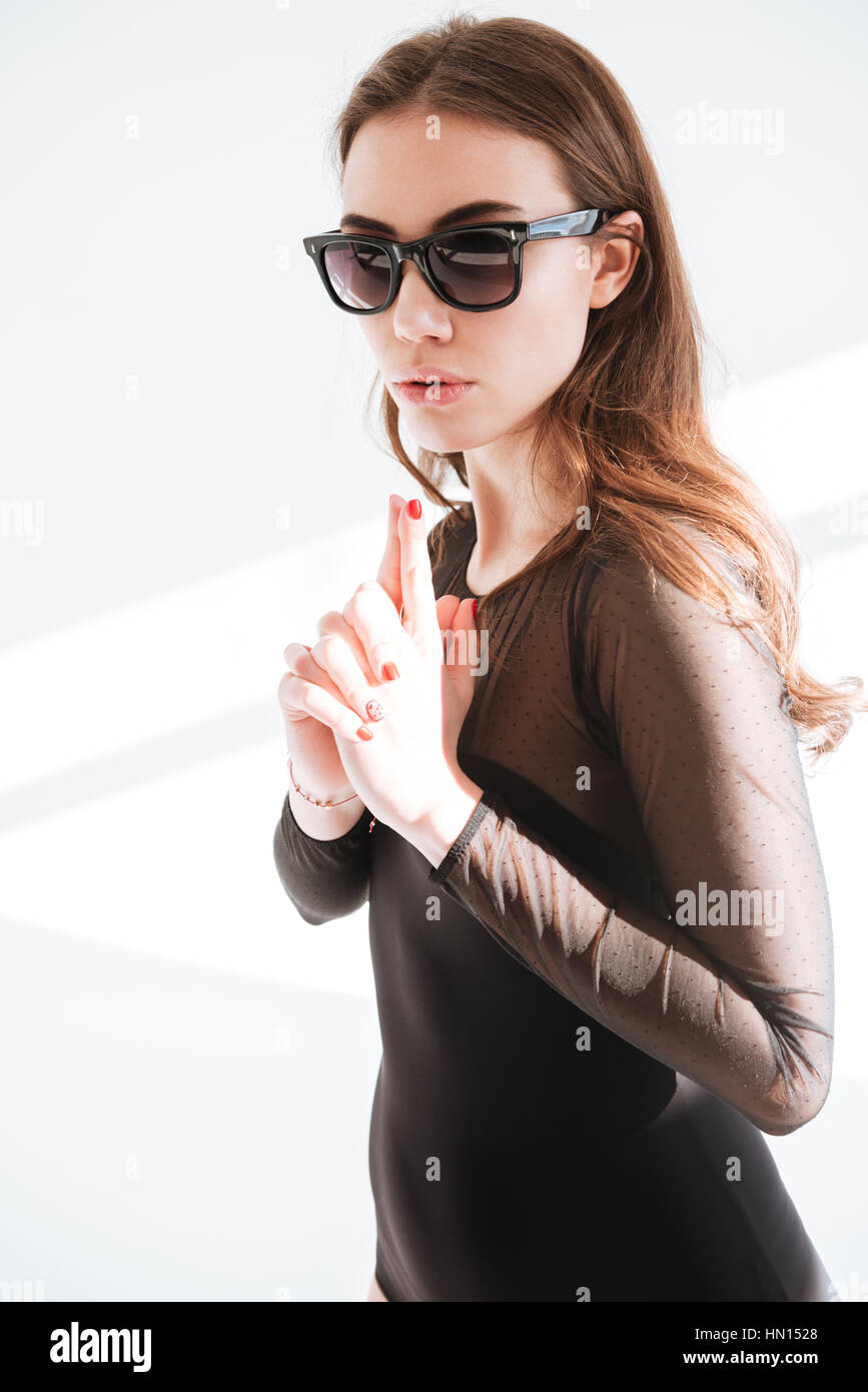 Image of young serious lady wearing sunglasses standing at studio over ...