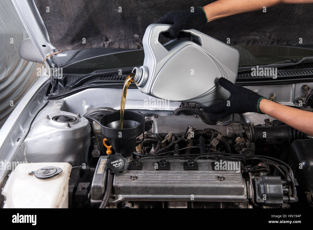 technician pouring fresh motor oil to engine of old car Stock Photo - Alamy