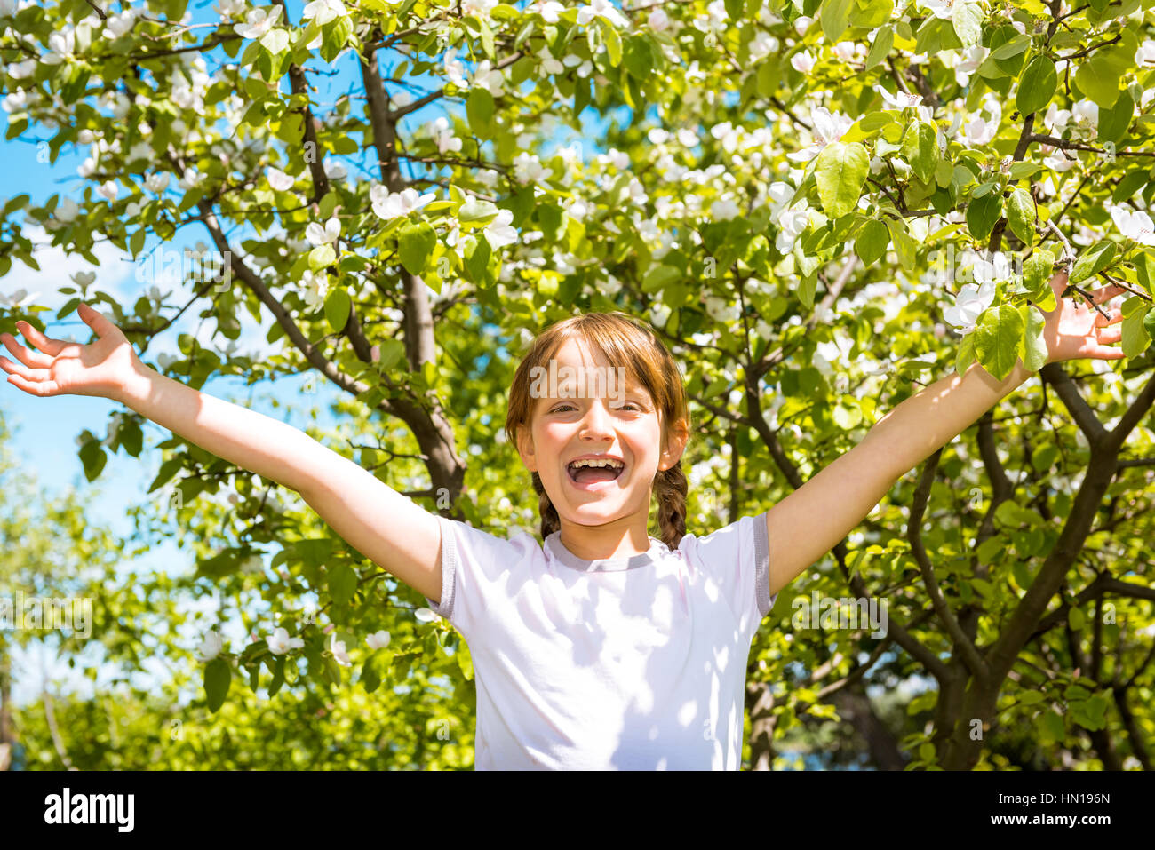 smiling child playing in spring flowered garden Stock Photo - Alamy