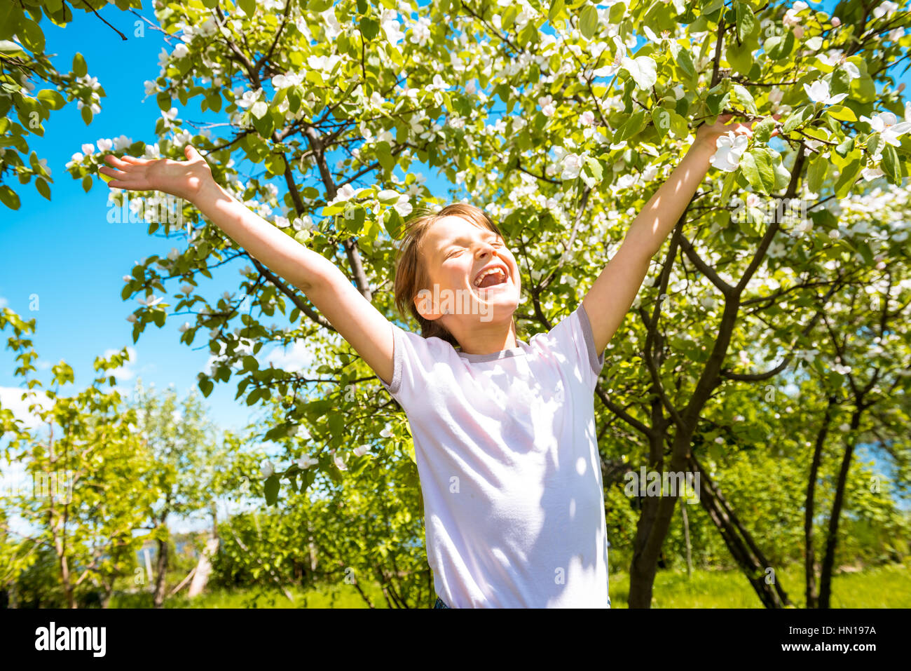 smiling child playing in spring flowered garden Stock Photo - Alamy