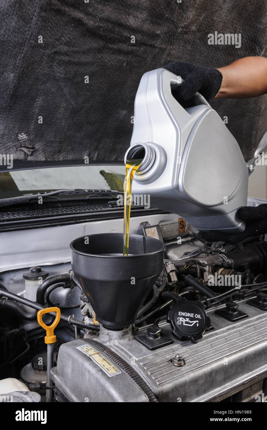 technician pouring fresh motor oil to engine of old car Stock Photo - Alamy