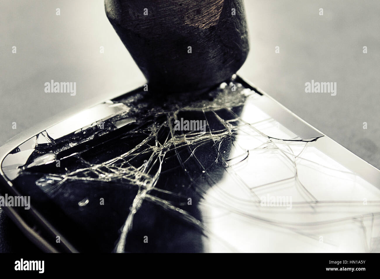 Broken phone screen and hammer on background,a hammer blow to the ...