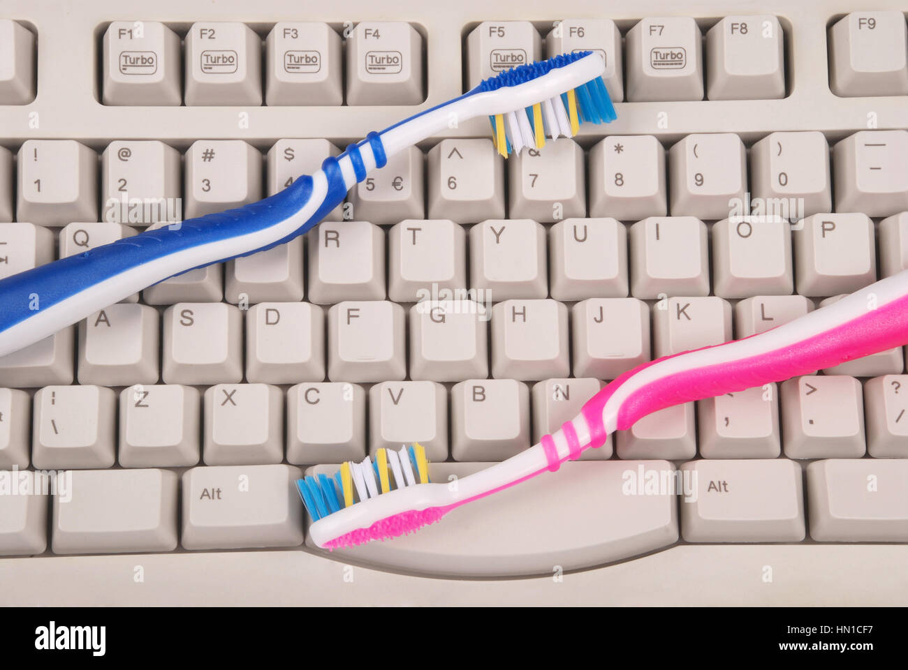 One computer keyboard and toothbrushes. Gray color Stock Photo - Alamy