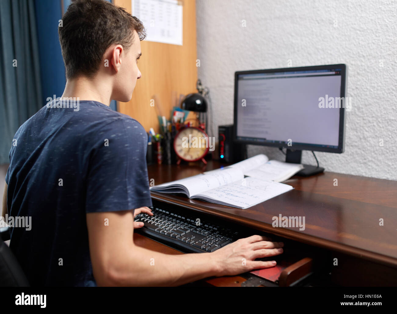 Teenage boy doing homework with the help of computer Stock Photo - Alamy