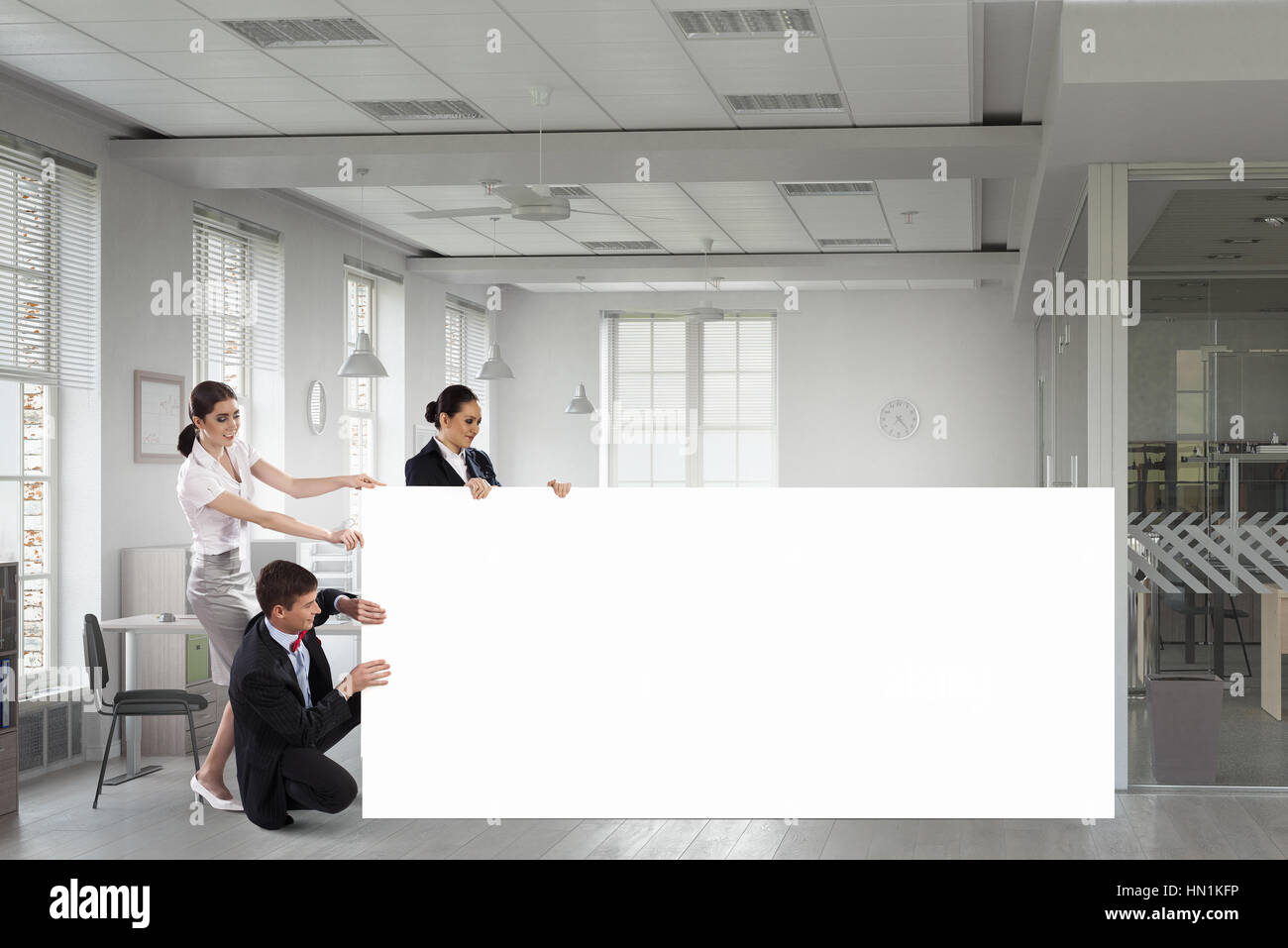 Group of young business people holding big blank banner. Mixed media ...