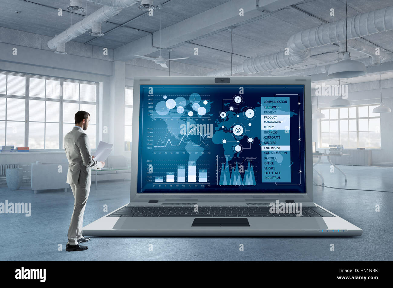 Young businessman and huge laptop with infographs on screen. Mixed ...