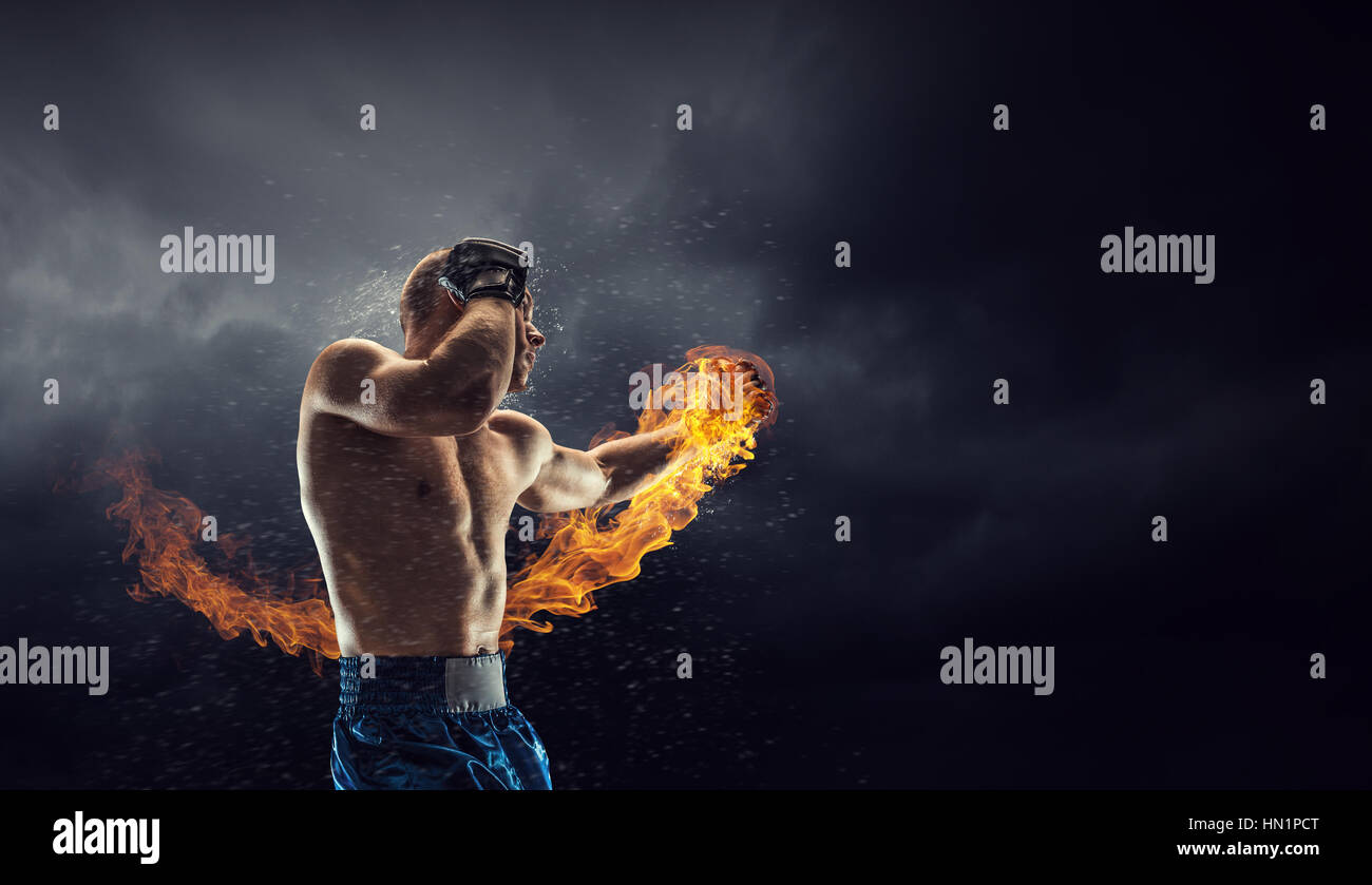 Strong fighter in shorts against dark sky background Stock Photo - Alamy