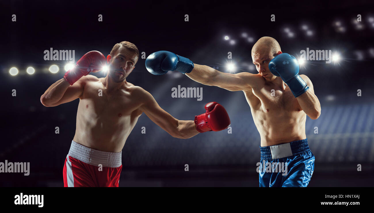 Two professional boxers fighting at sport arena. Mixed media Stock ...