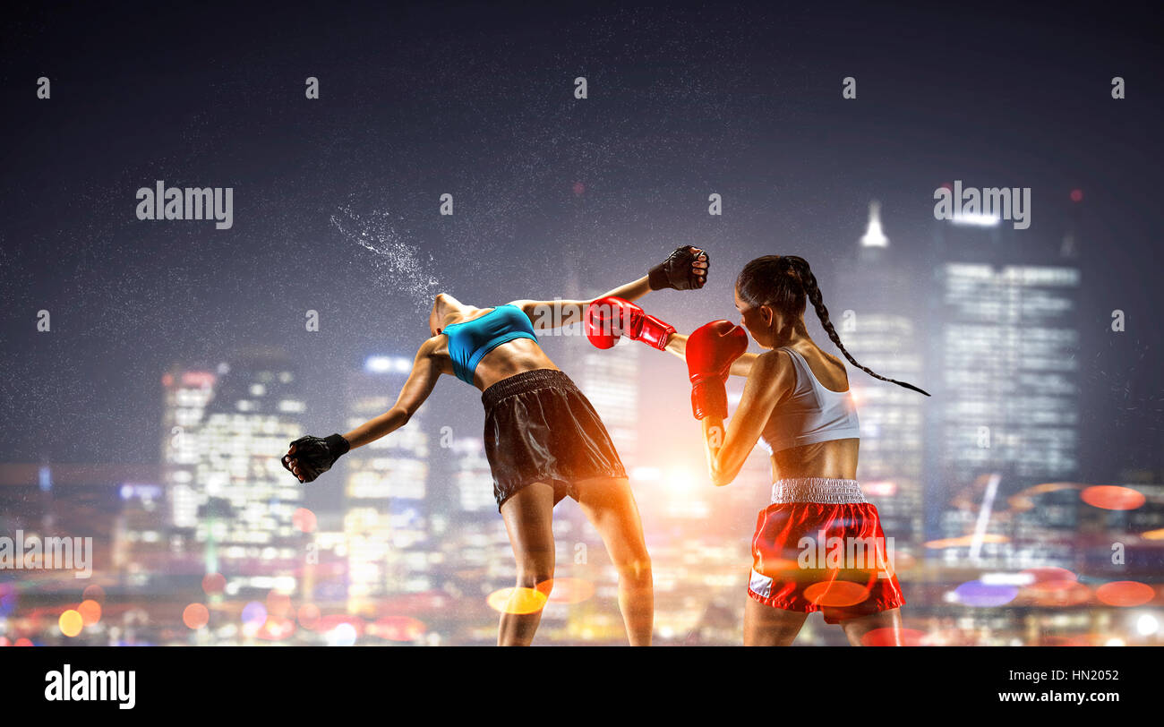 Two young pretty women boxing against night city background Stock Photo ...