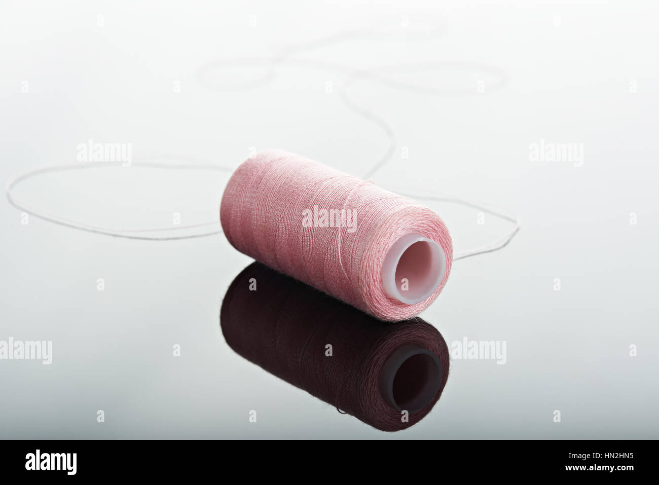 one wool pink thread lay horizontal isolated on white Stock Photo - Alamy