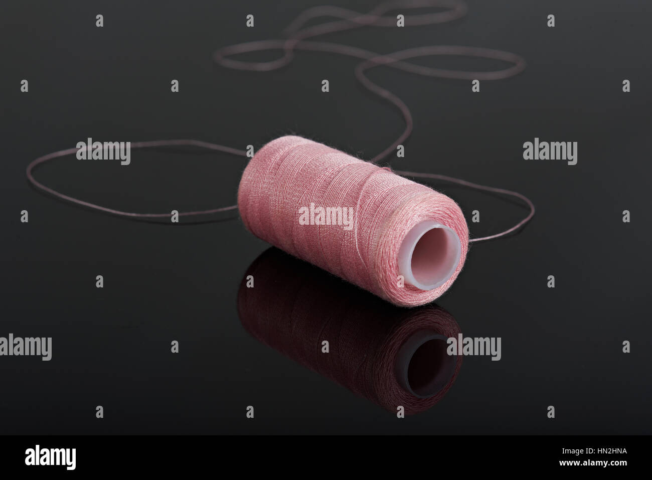 one pink thread isolated on black background Stock Photo - Alamy