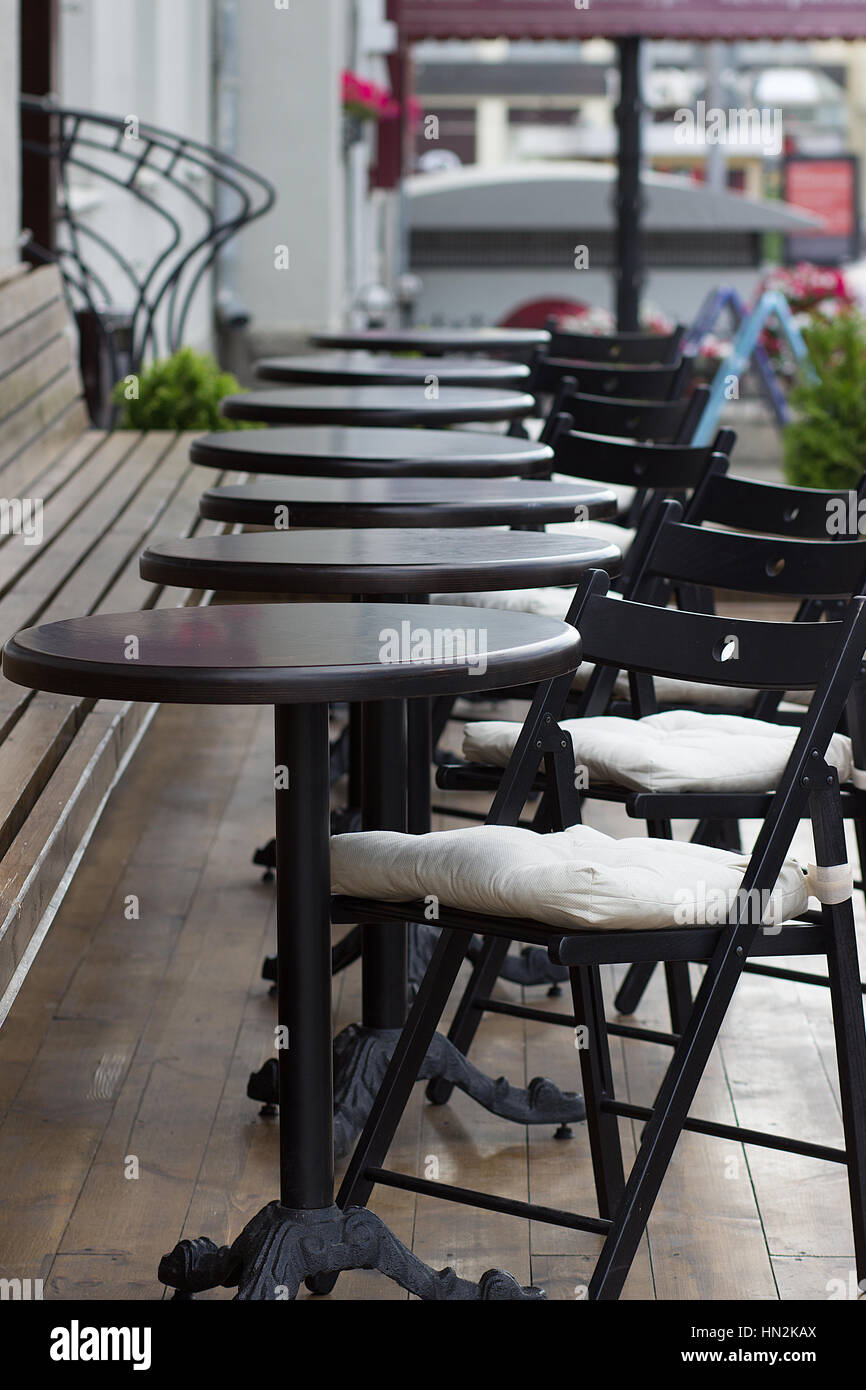 Tables and chairs of street cafes in the city Stock Photo - Alamy