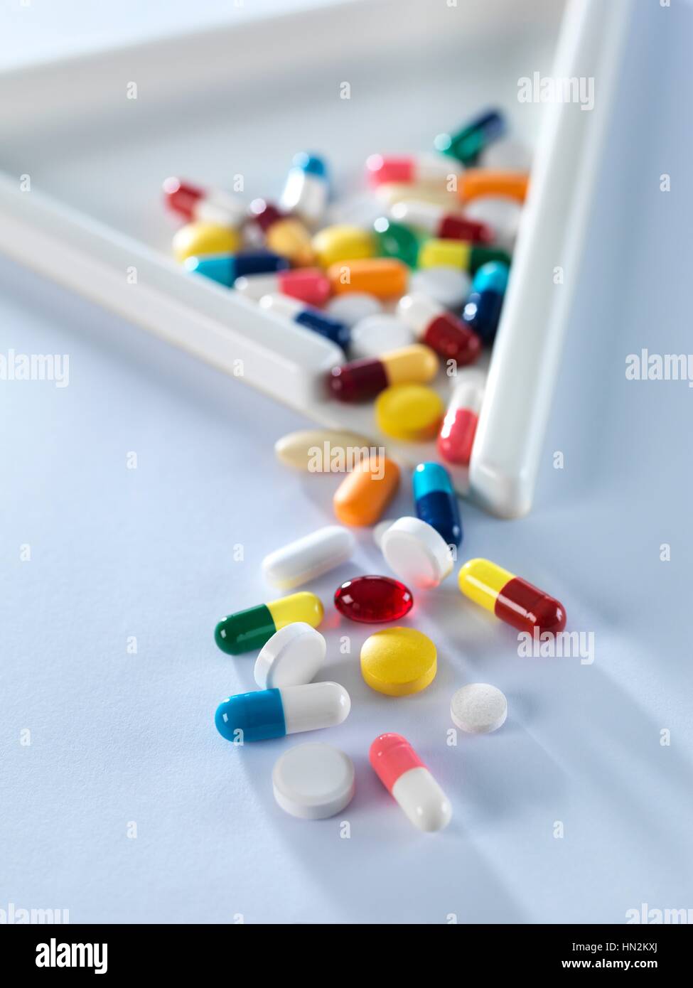 Pills pouring out of measuring triangle Stock Photo - Alamy