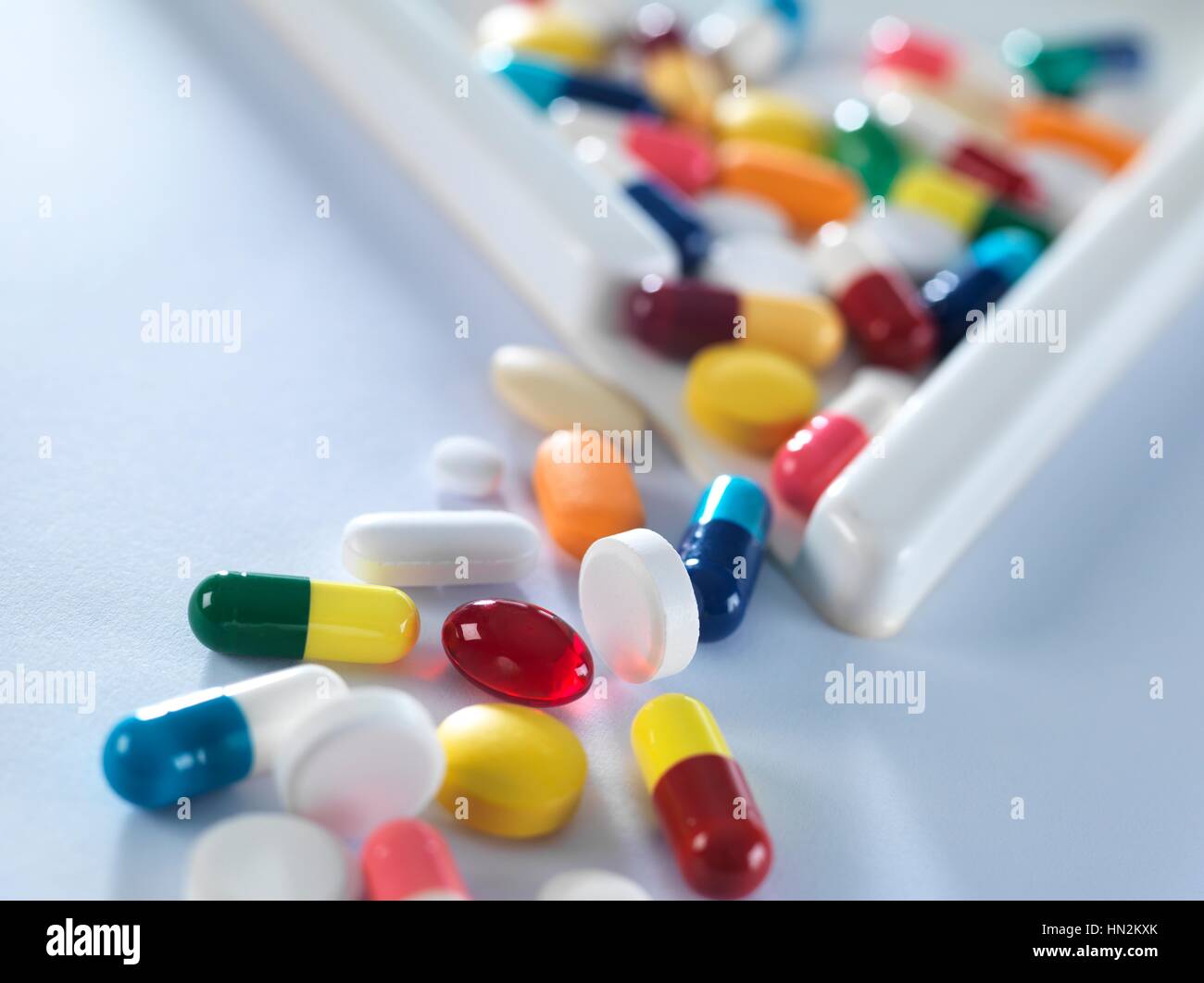 Pills pouring out of measuring triangle Stock Photo - Alamy