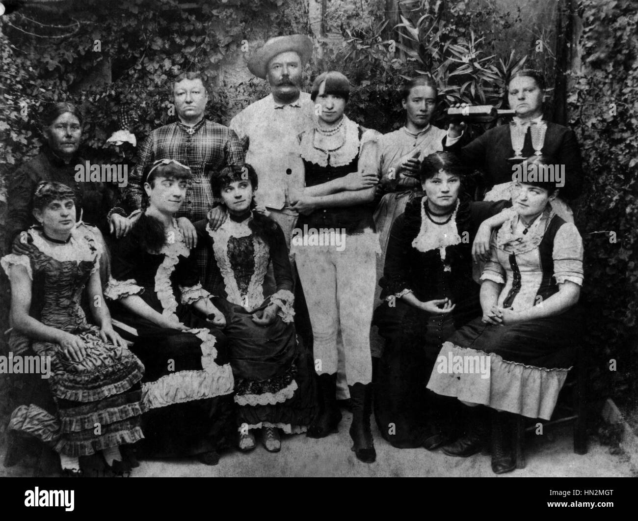 Boss of a brothel, surrounded by his ladies of pleasure France c.1900 ...