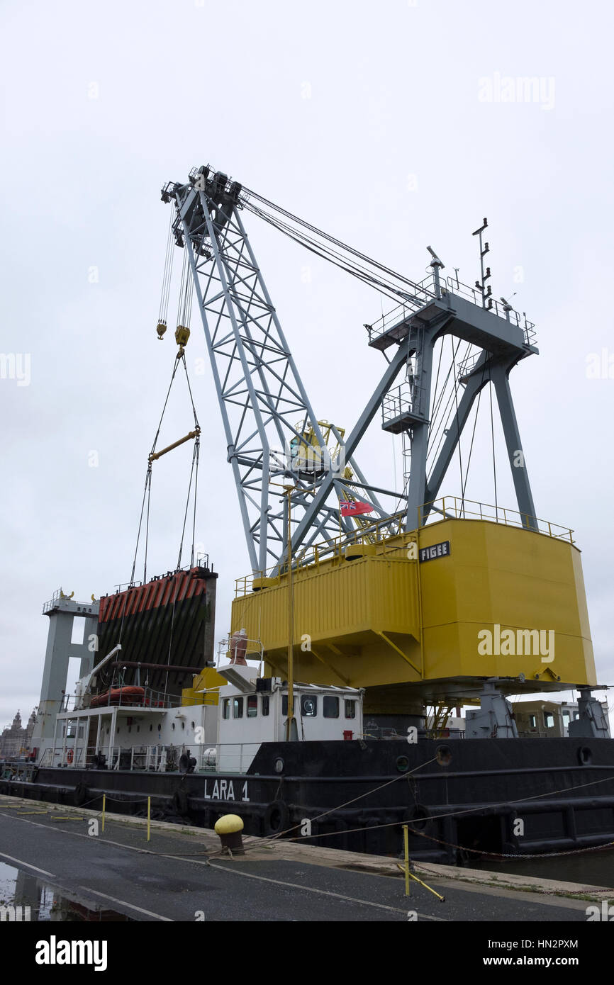 Crane on ship loading a dock wall Stock Photo - Alamy