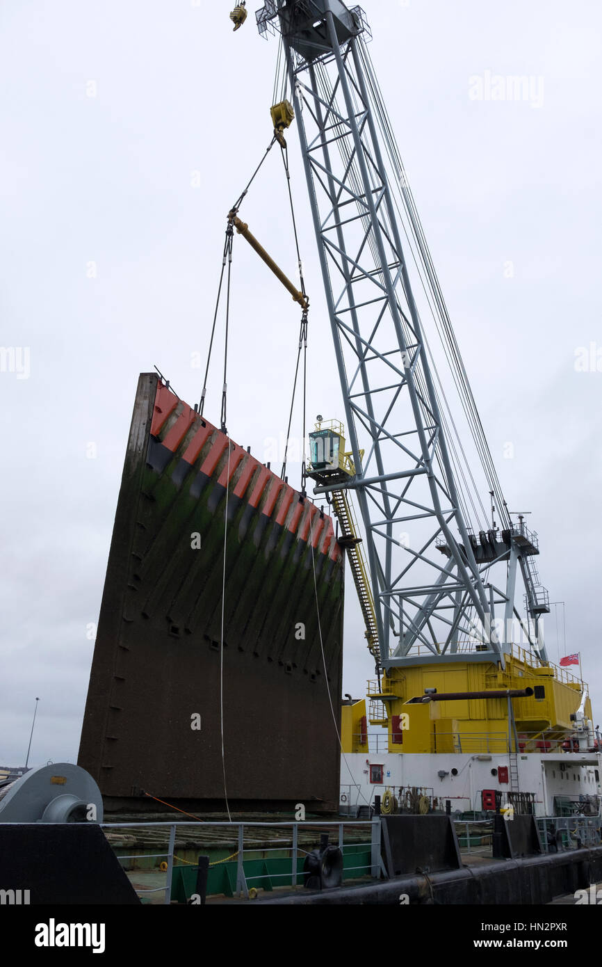 Crane on ship loading a dock wall Stock Photo - Alamy