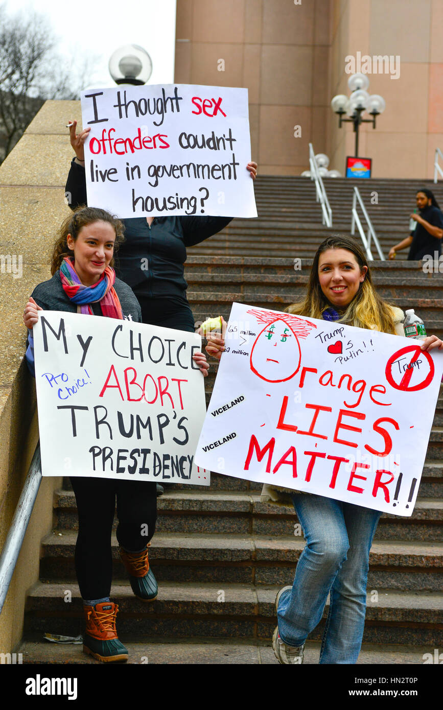 Three woman on stairs holding anti-Trump political signs at the Women's ...