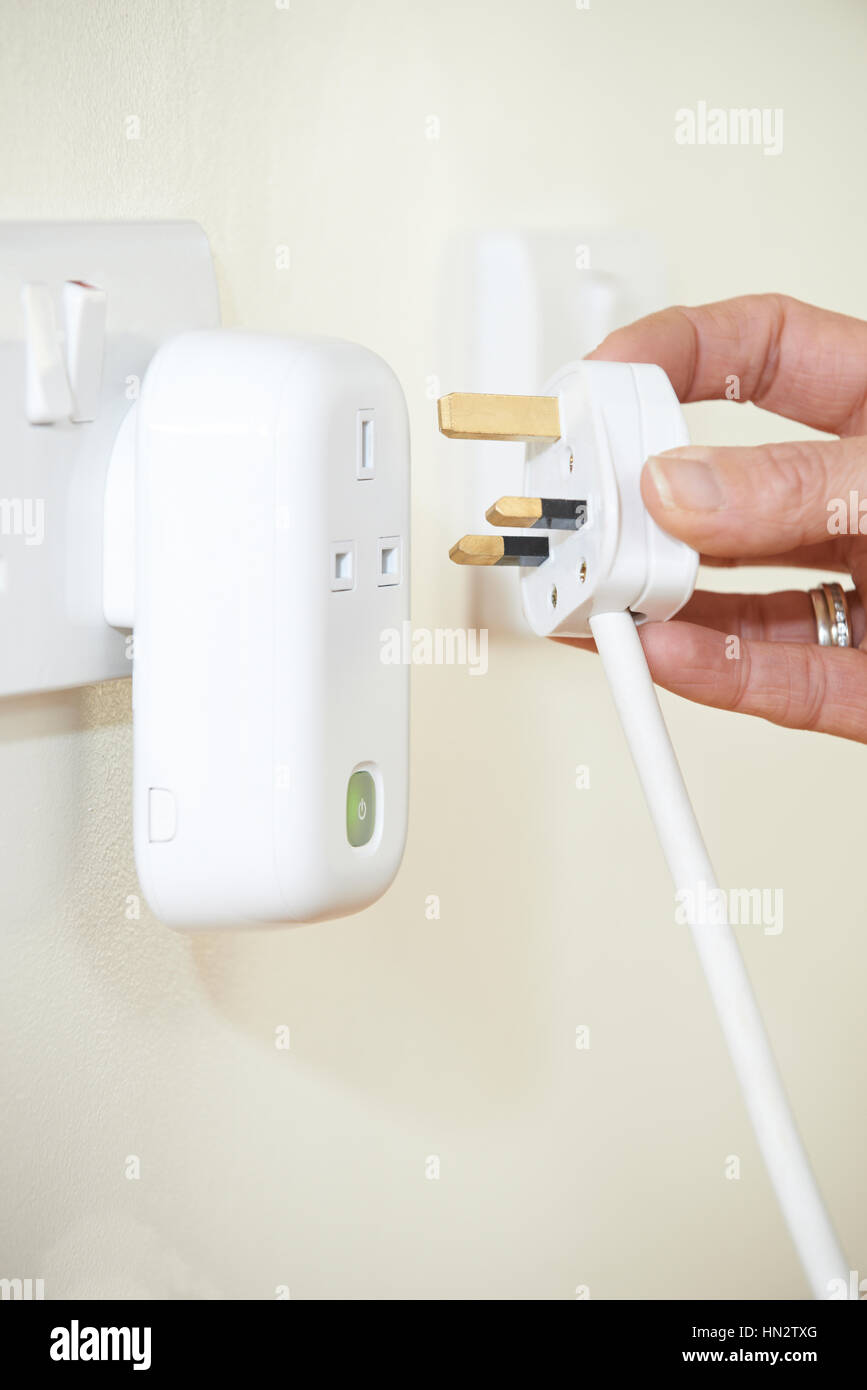 Woman Putting Plug Into Smart Electricity Socket Stock Photo - Alamy