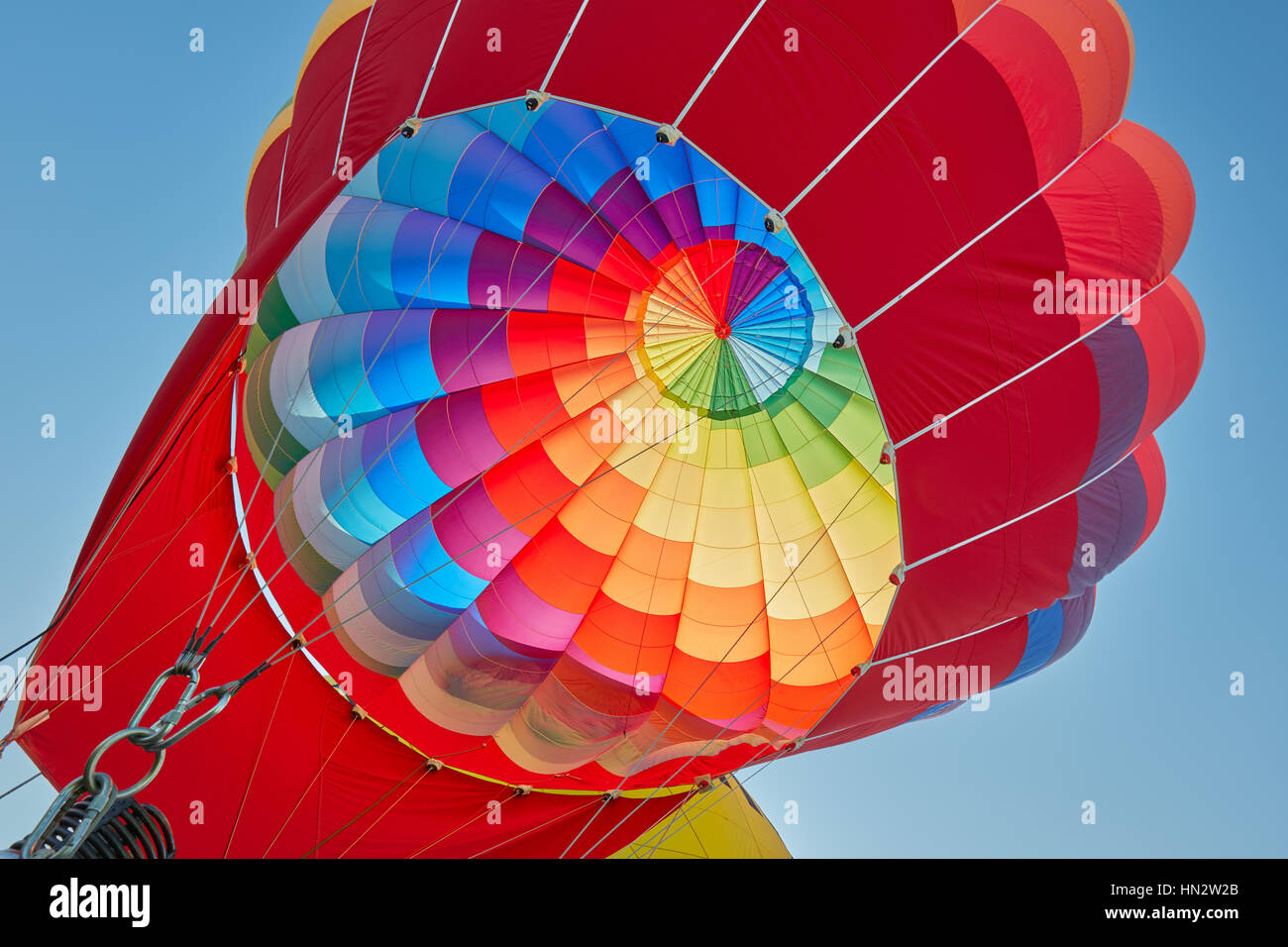 Hot air balloon, colorful aerostat inflating, blue sky Stock Photo - Alamy