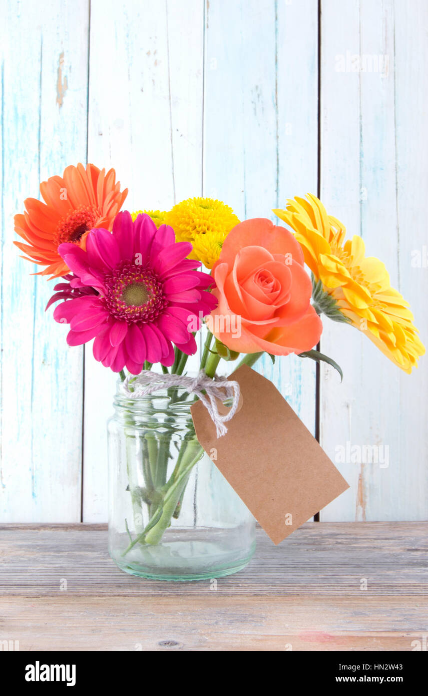 Bunch of flowers with blank gift label on wooden background Stock Photo ...