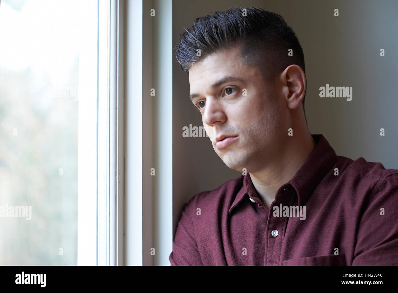 Sad Man Suffering From Depression Looking Out Of Window Stock Photo - Alamy