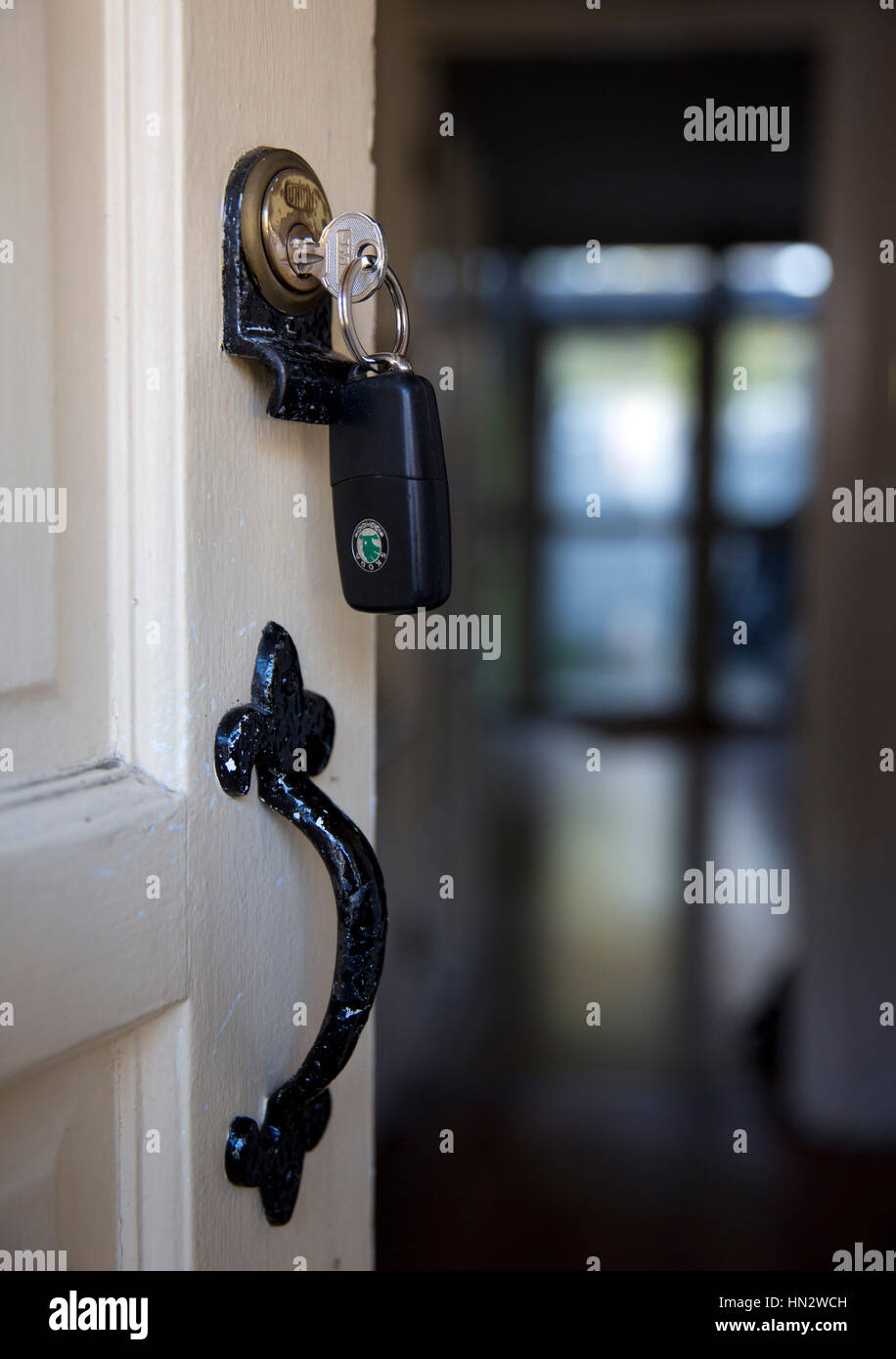A set of house keys are seen in a lock on the front door to a house in ...