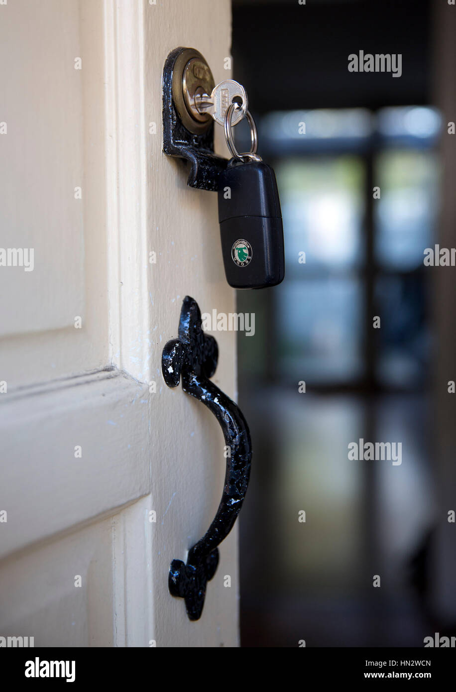 A set of house keys are seen in a lock on the front door to a house in ...