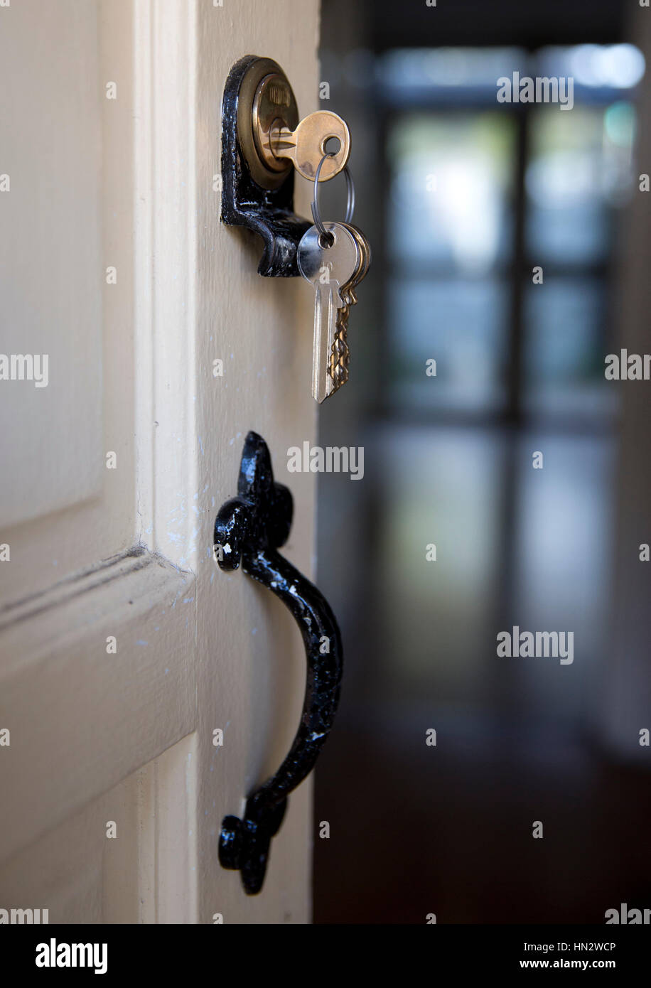 A set of house keys are seen in a lock on the front door to a house in ...