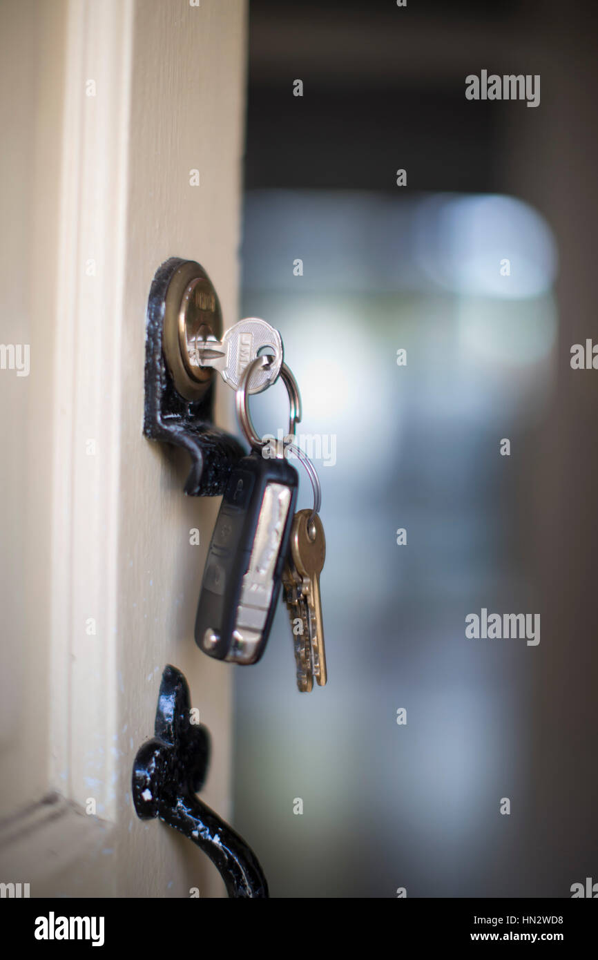 A set of house keys are seen in a lock on the front door to a house in ...