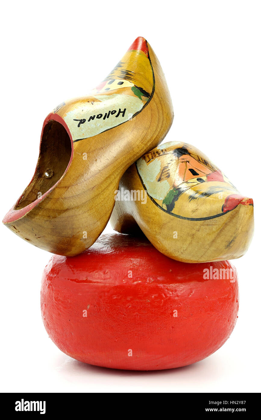 Edam cheese wheel with nostalgic Dutch souvenir clogs isolated on white ...