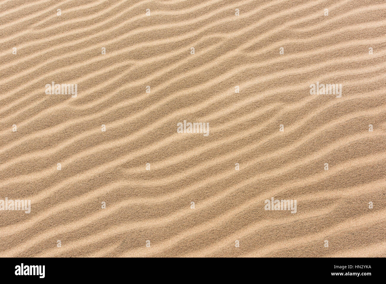 Textured sand of yellow color as background Stock Photo - Alamy