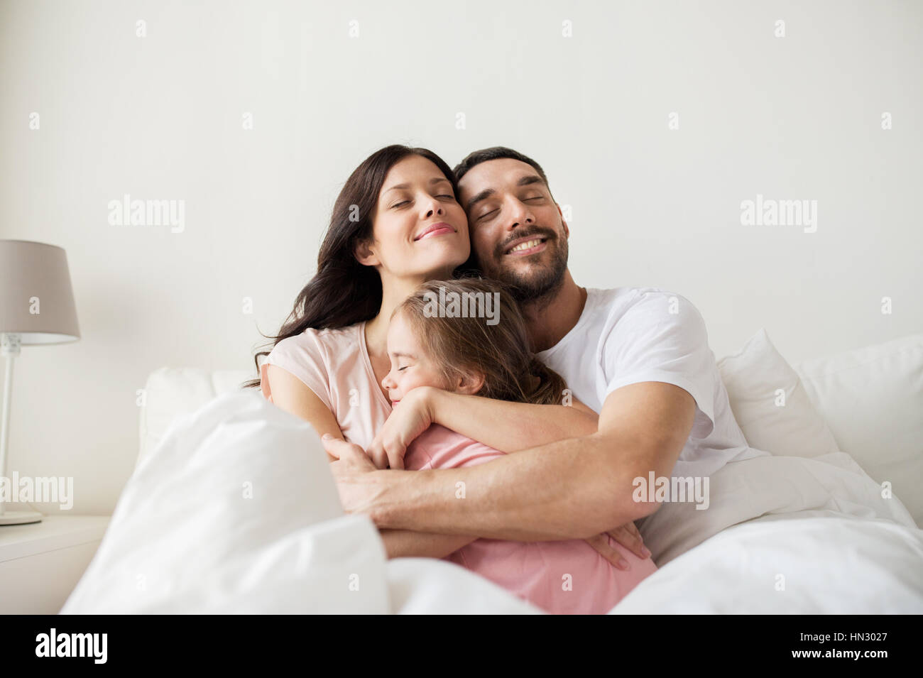 happy family hugging in bed at home Stock Photo - Alamy