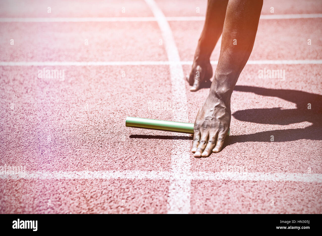 Hands of athlete holding baton on running track Stock Photo - Alamy