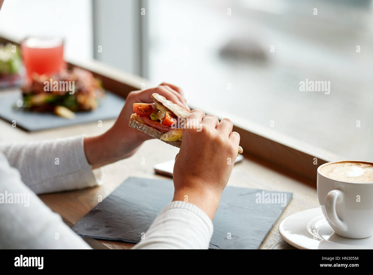 woman eating salmon panini sandwich at restaurant Stock Photo - Alamy