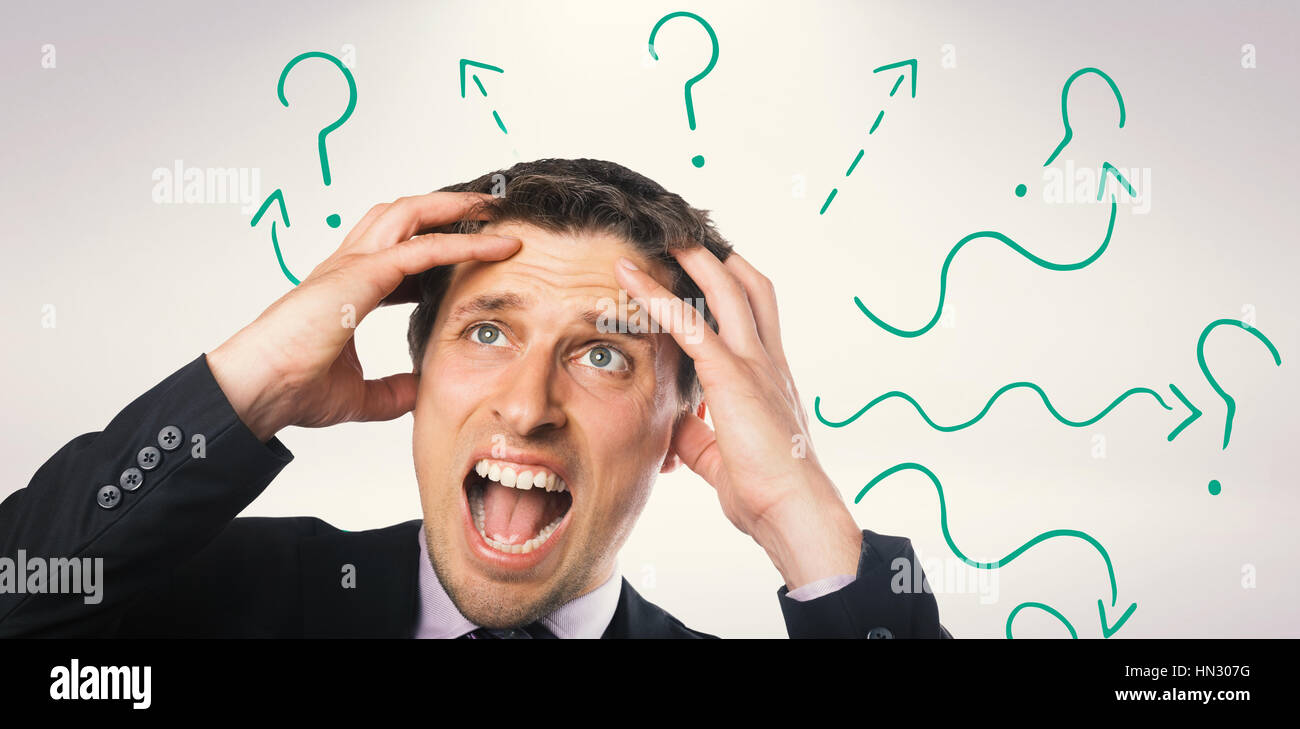 Close-up of frustrated businessman looking up against grey background ...