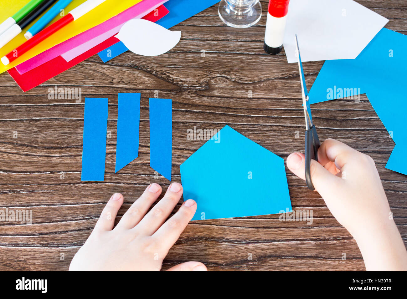 The child cuts out paper details. The child create a spring greeting ...