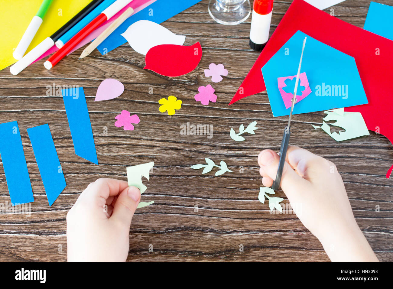 The child cuts out paper details. The child create a spring greeting ...
