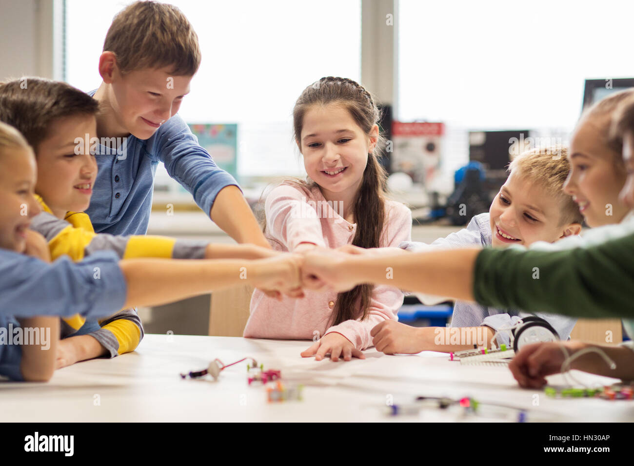 happy children making fist bump at robotics school Stock Photo - Alamy