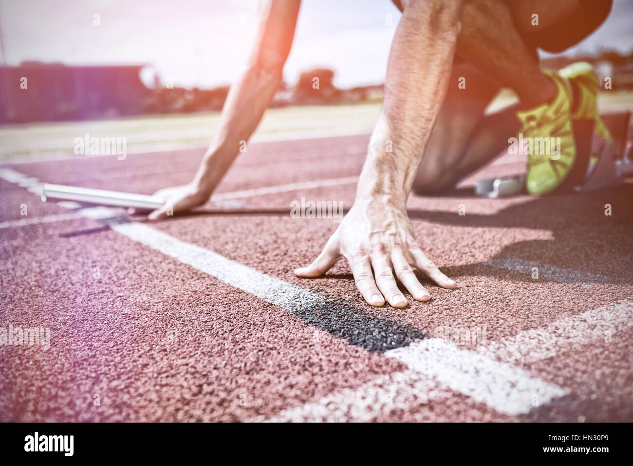 Athlete ready to start the relay race on running track Stock Photo - Alamy
