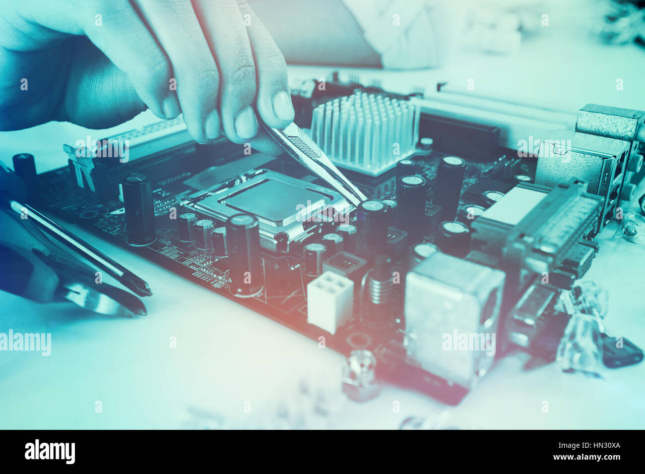 Close-up of female computer engineer repairing computer motherboard ...