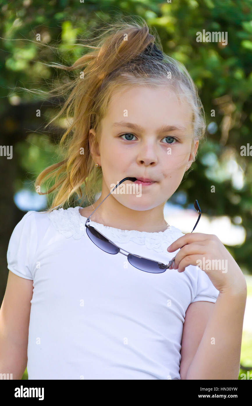 Cute girl playing with sunglasses in summer Stock Photo - Alamy