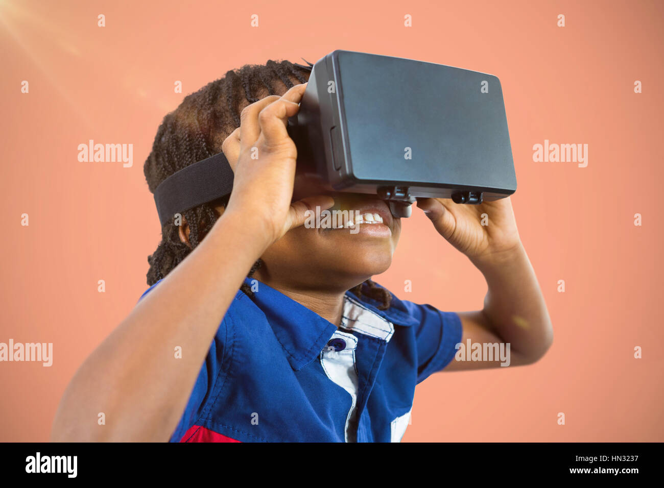 Boy wearing virtual reality simulator against pink background Stock ...